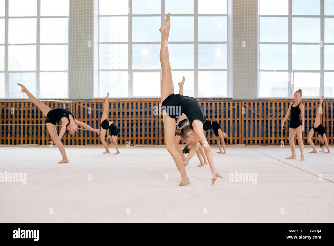 Group of Caucasian girls performing rhythmic gymnastics routine in ...