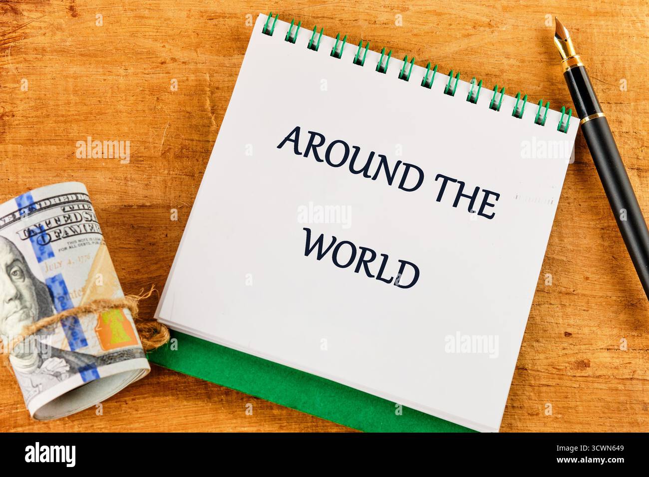 A notepad with the words AROUND THE WORLD sits next to a roll of one ...
