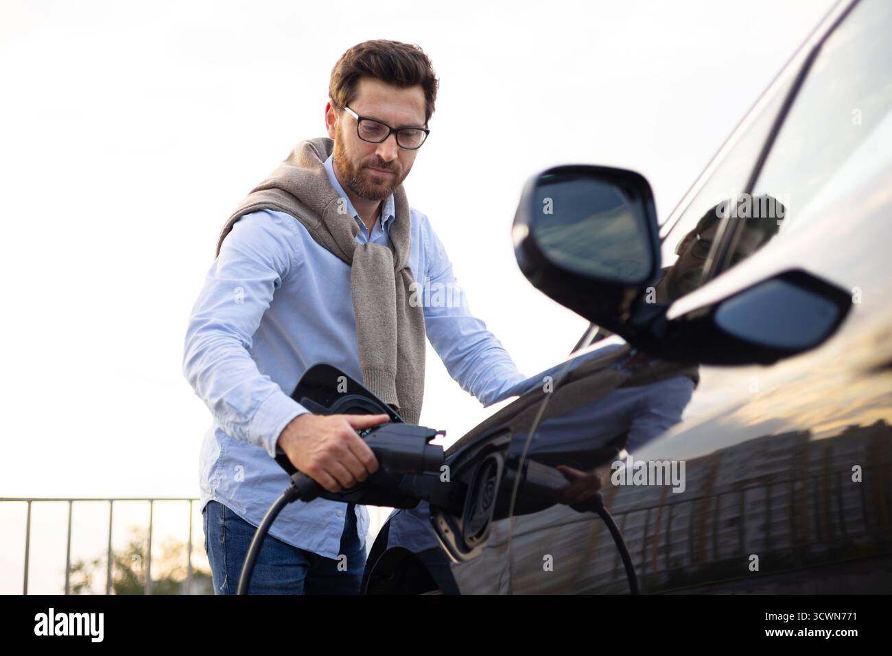 Man connecting electric vehicle charger hi-res stock photography and ...