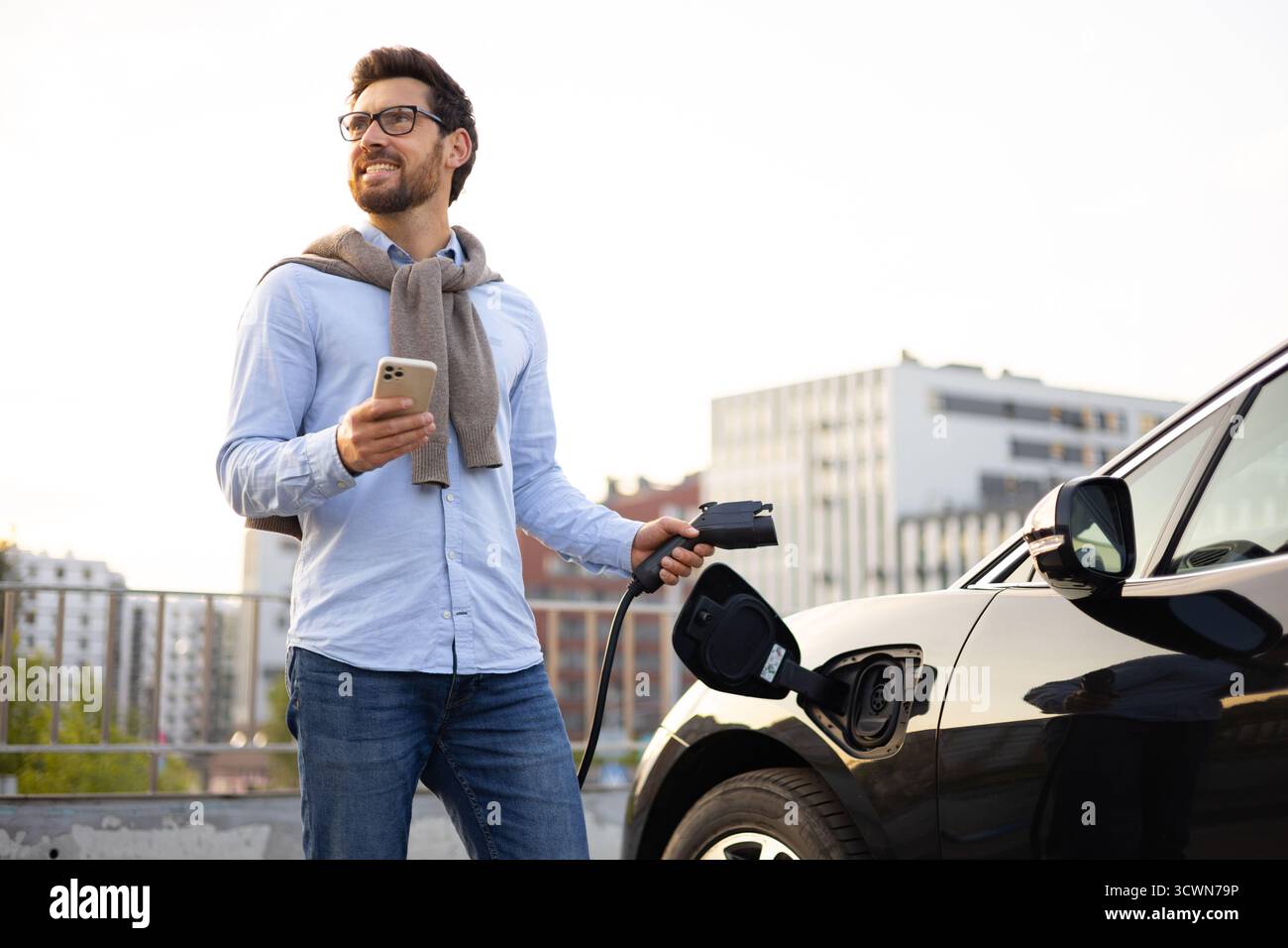 Man Charging Electric Vehicle Stock Photo - Alamy