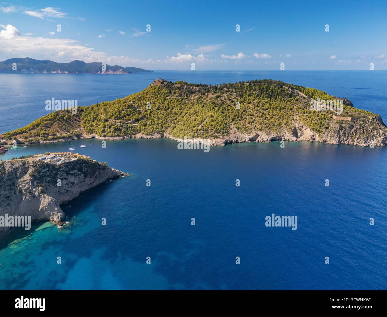 Aerial view of a rugged, verdant island rises majestically from the ...