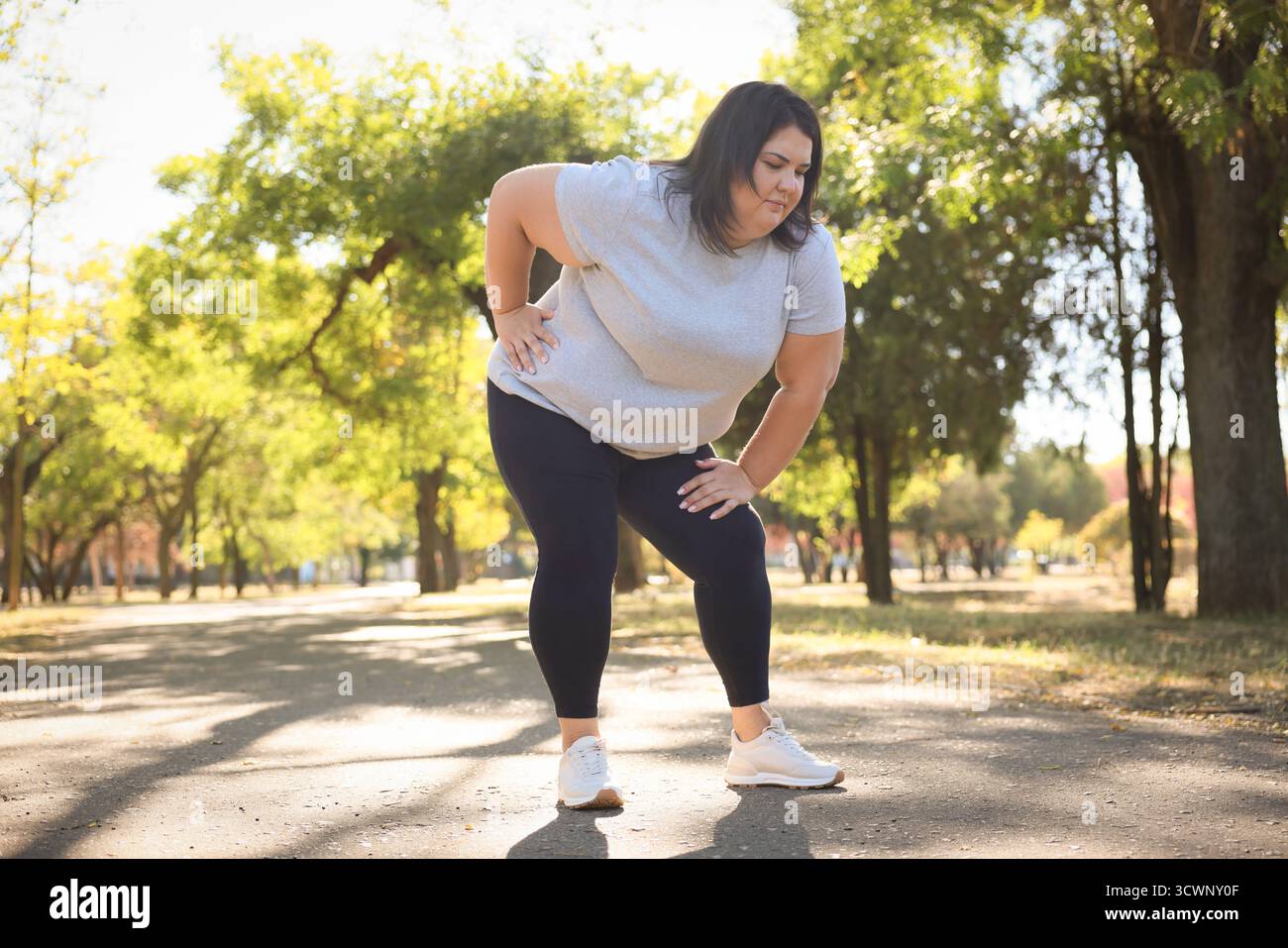 Tired overweight woman after running in park Stock Photo - Alamy