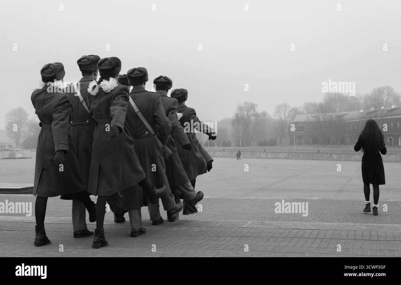 Group of uniformed soldiers marching in formation on a foggy day as a ...