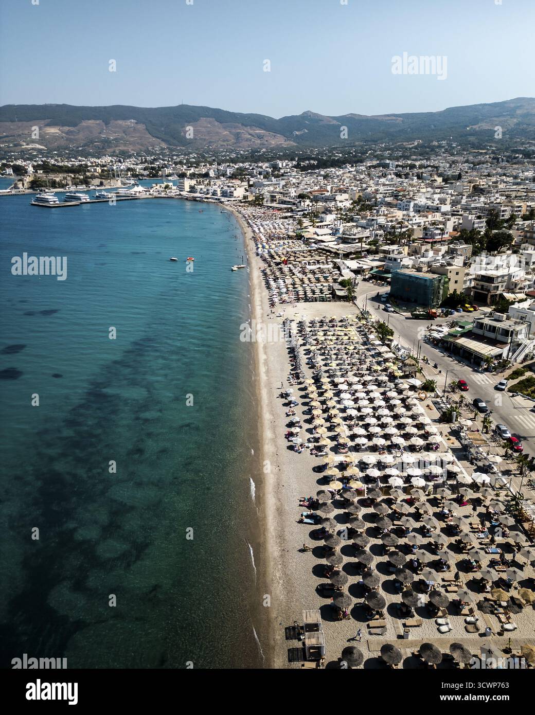 Aerial view of sun-drenched beach umbrellas line the sandy shores where ...