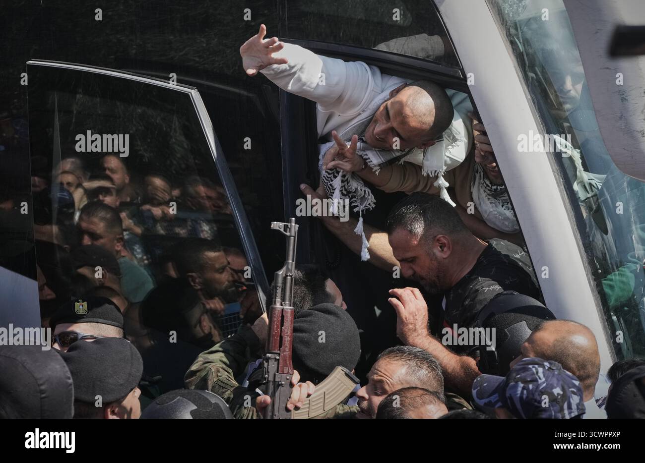 Palestinian prisoners wave to the crowd after being released from ...