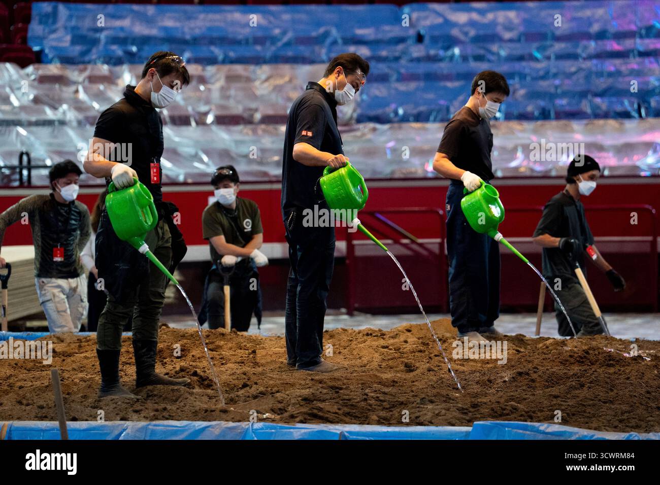 The soil is watered during the construction of the dohyo in the ...