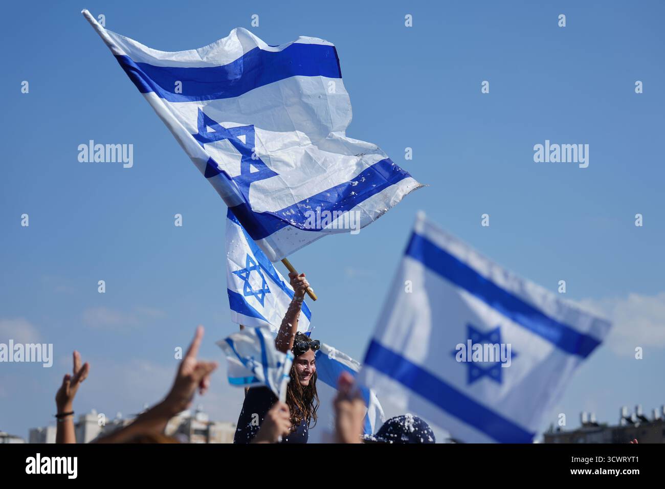 People hold Israeli flag in celebration after the arrival of freed ...