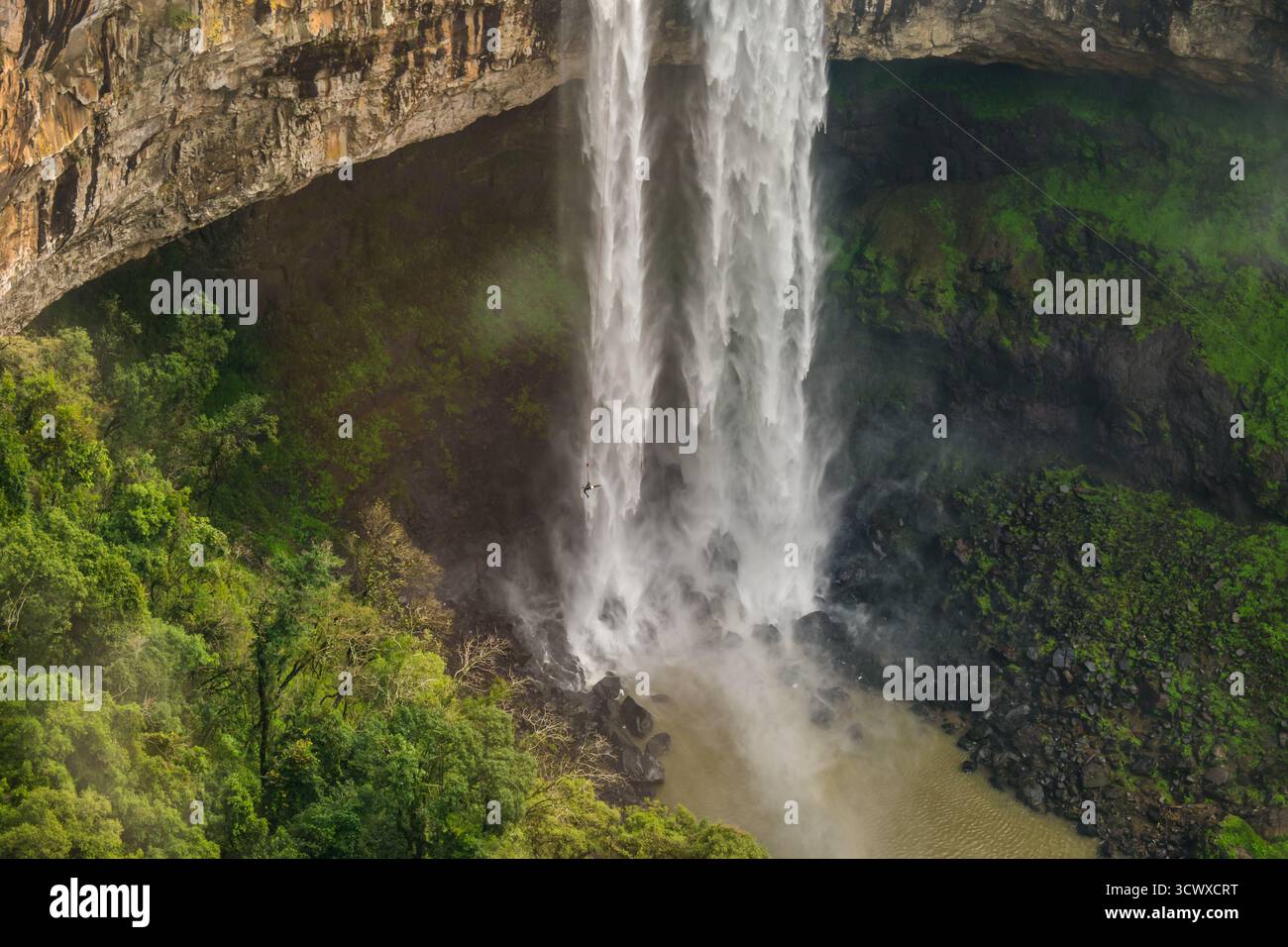 A view of Cascata do Caracol waterfall and person bungee jumping at ...