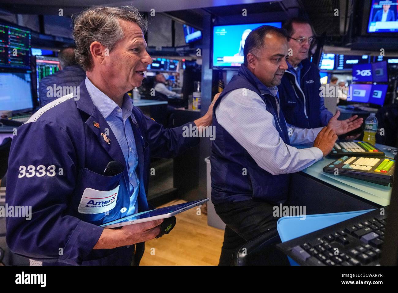 Trader Robert Charmak, left, and specialist Dilip Patel, center, work ...