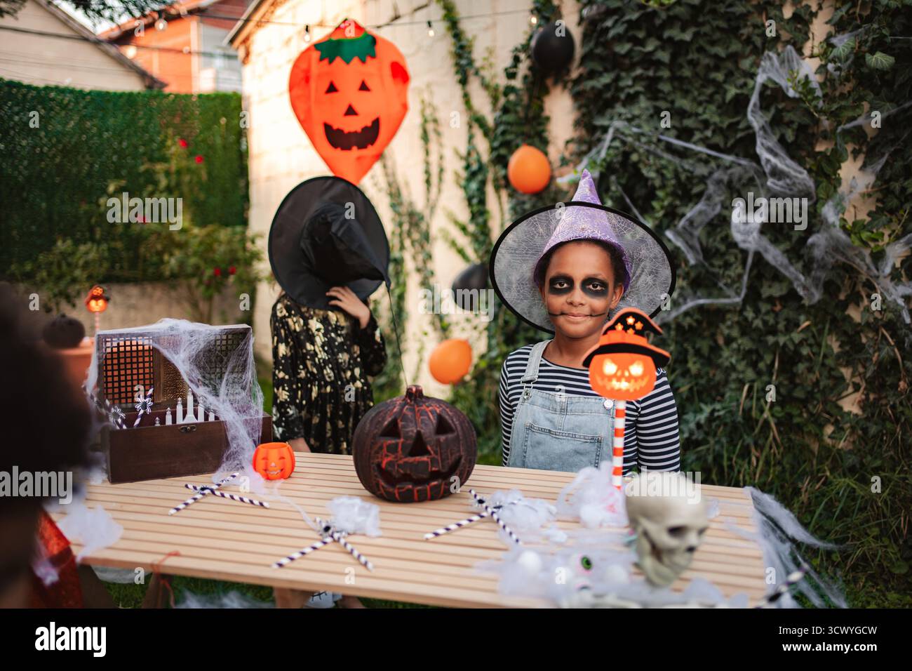 Children celebrating Halloween wearing costumes at a masquerade ball ...