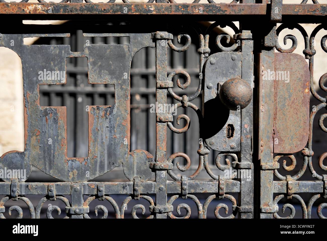 Ornate slightly rusty metal gate with lock and cross Stock Photo - Alamy