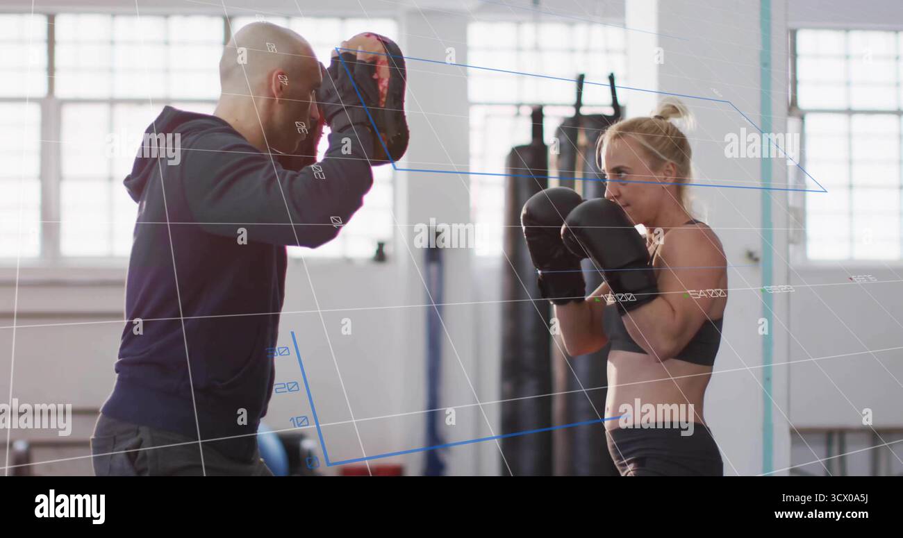 Training female boxer wearing black boxing gloves punching focus mitts ...