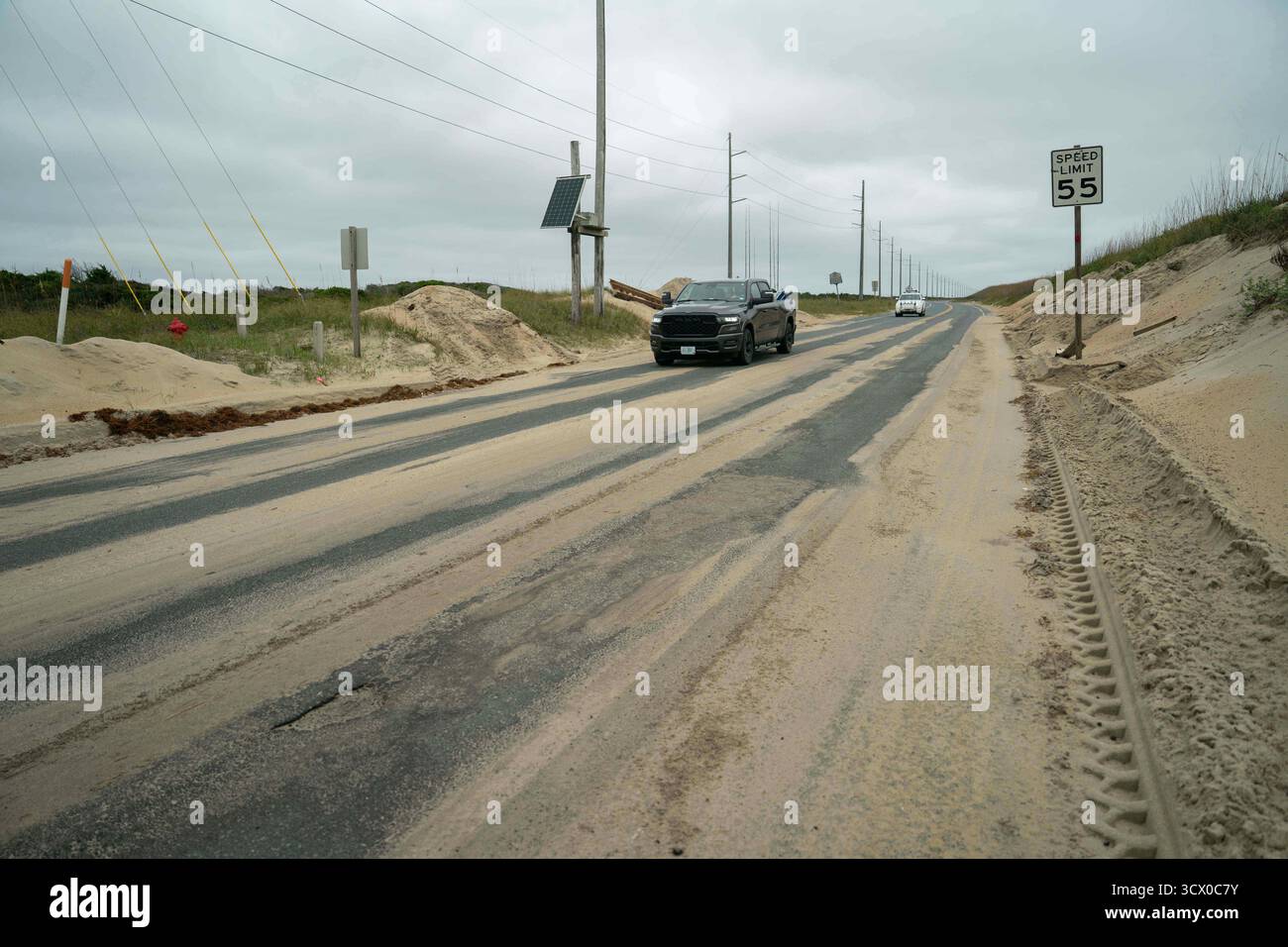 A car drives over sand on Highway 12 after a storm, Monday, Oct. 13 ...