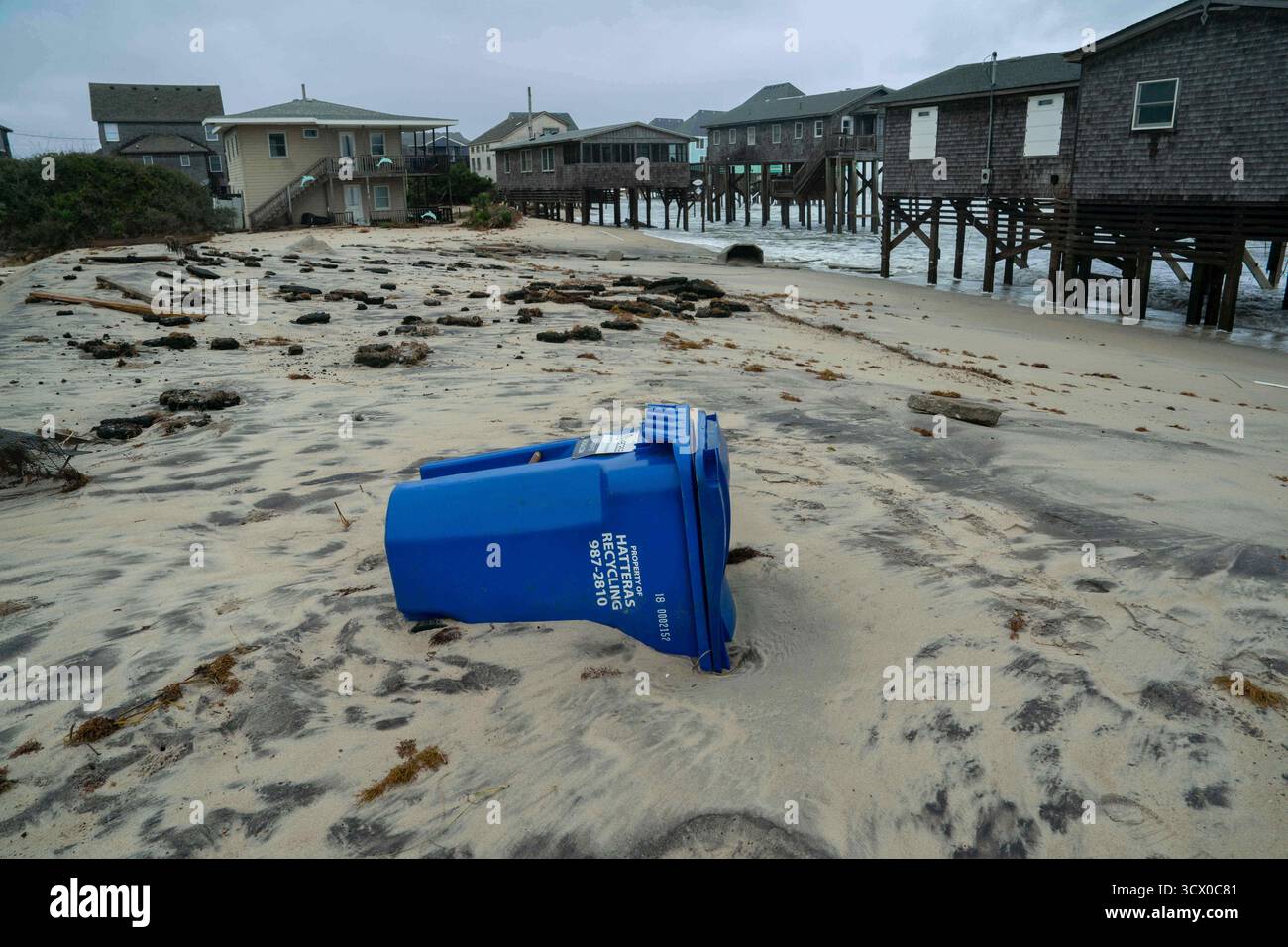 A recycling bin sits on a beach after a storm, Monday, Oct. 13, 2025 ...