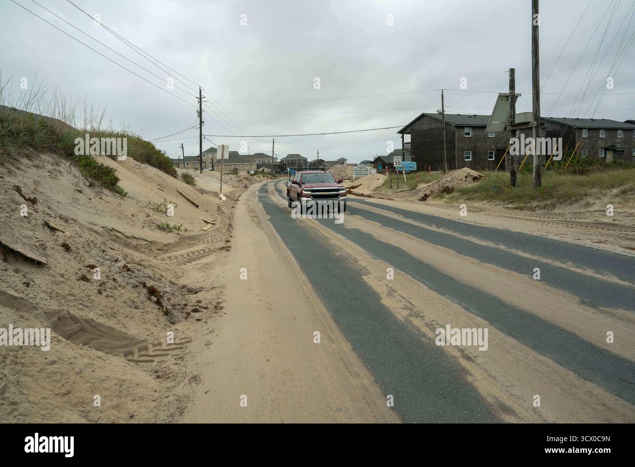 A car drives over sand on Highway 12 after a storm, Monday, Oct. 13 ...