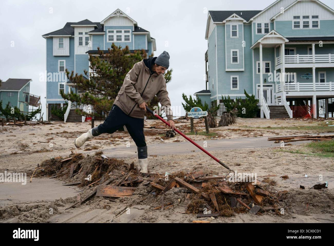 Bobby Piers Jr. rakes debris after a storm, Monday, Oct. 13, 2025, in ...