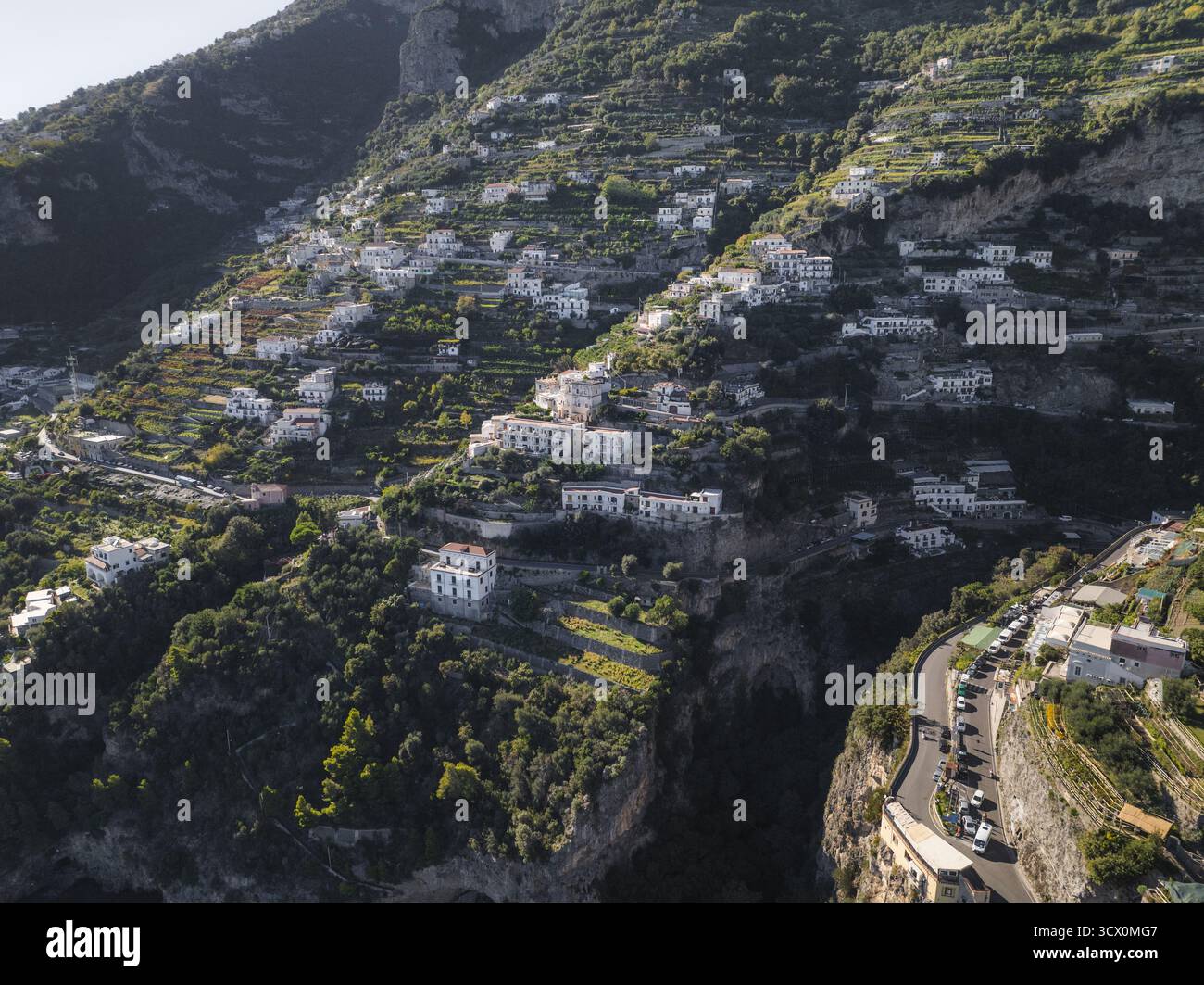 Aerial view of white buildings nestled into the verdant hillside ...