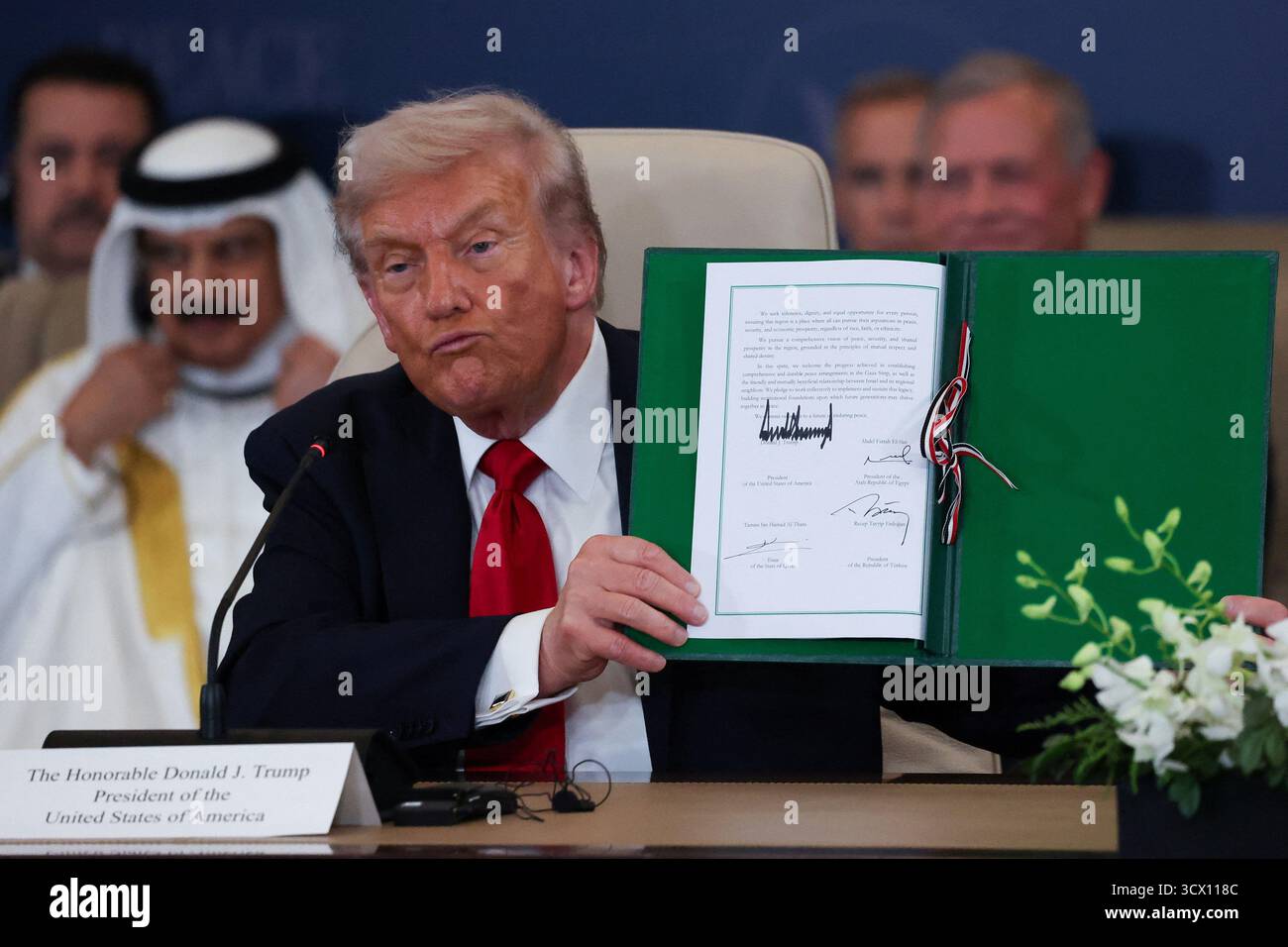US President Donald Trump poses with the signed agreement during the ...