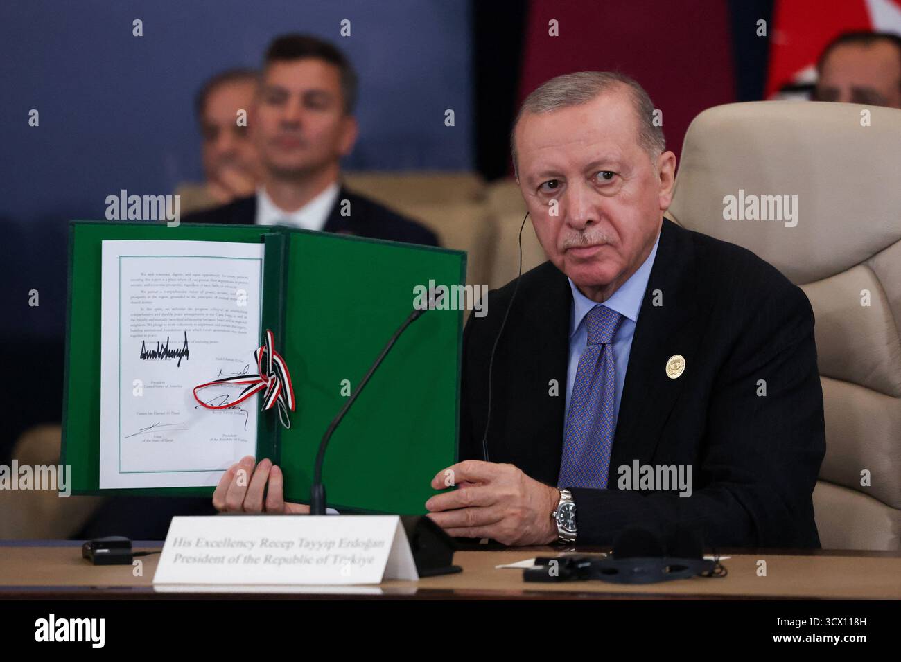 Turkish President Recep Tayyip Erdogan poses with the signed agreement ...