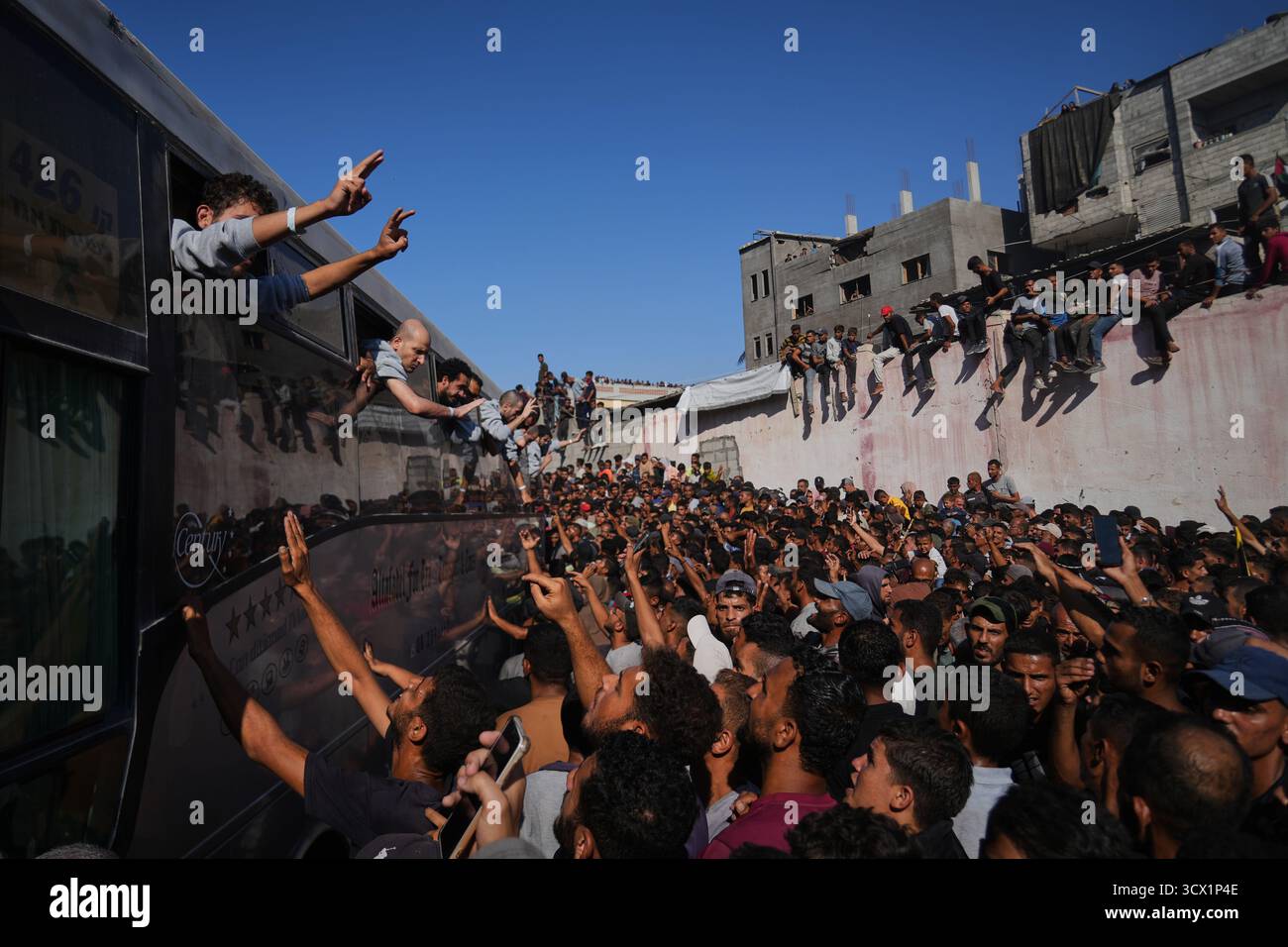 People gather to greet freed Palestinian prisoners arriving on buses in ...