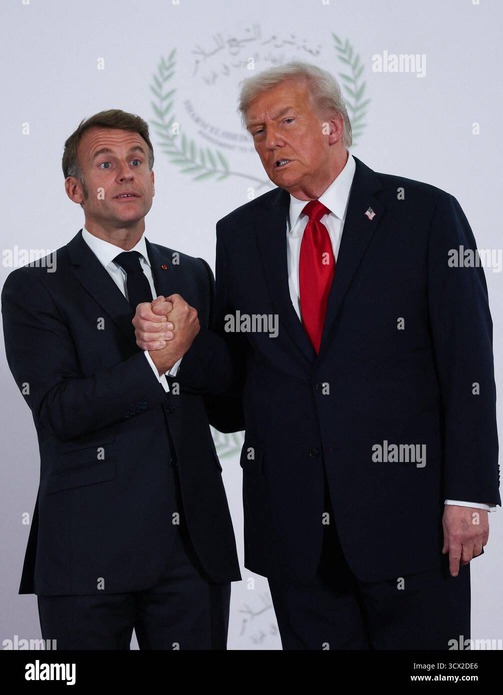 French President Emmanuel Macron (left) shakes hands with US President ...