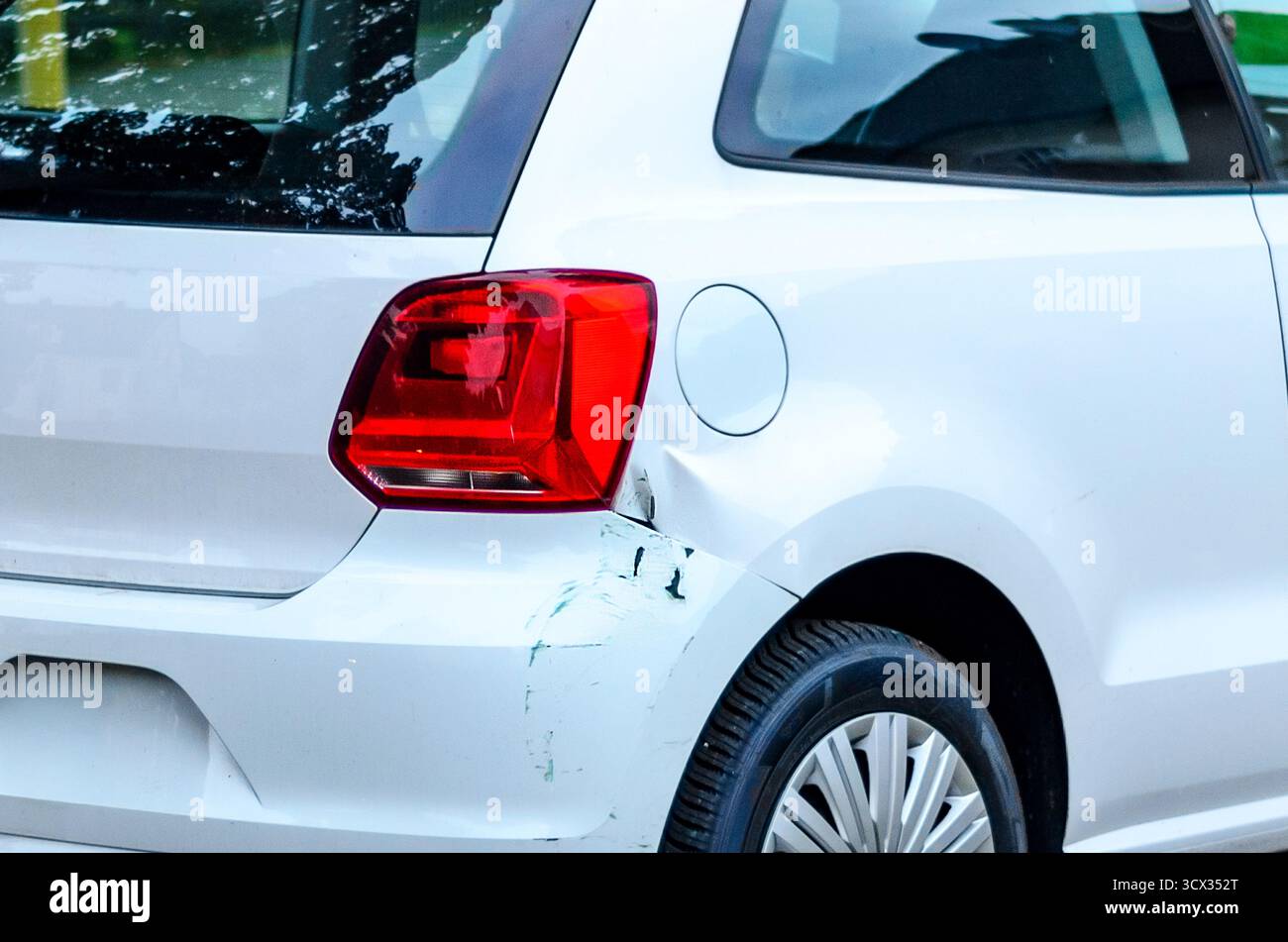 White car with rear bumper and quarter panel damage after collision ...
