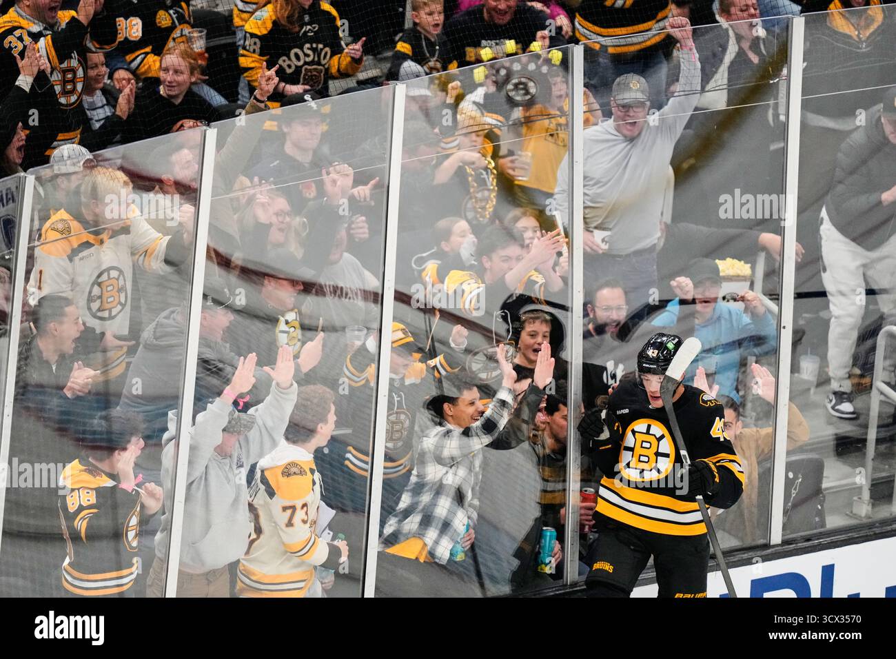 Boston Bruins defenseman Jordan Harris (43) leaps into the glass while ...