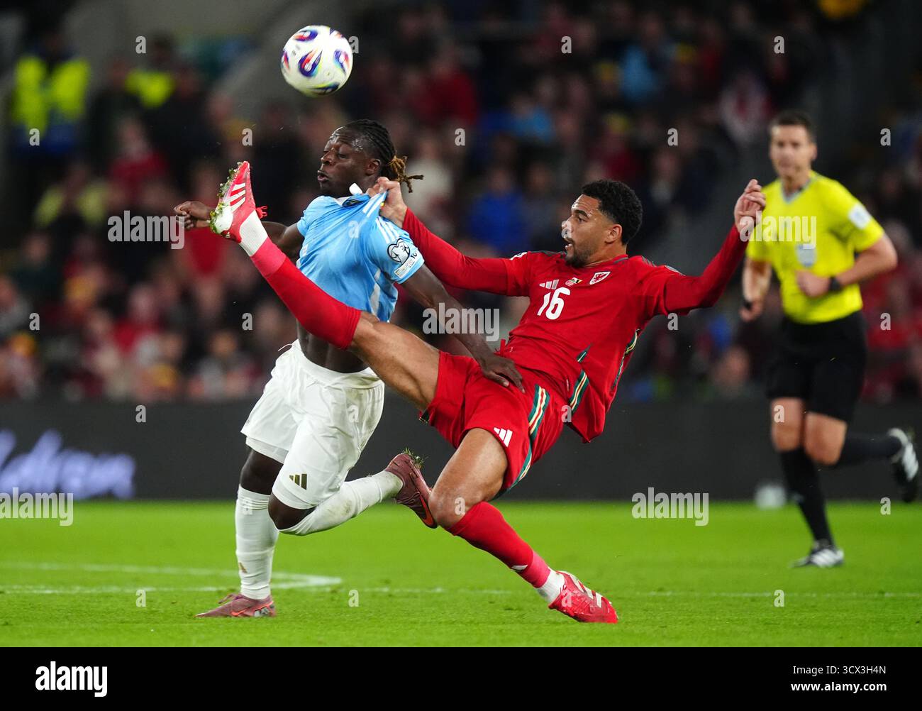 Belgium's Jeremy Doku (left) and Wales' Ben Cabango battle for the ball ...