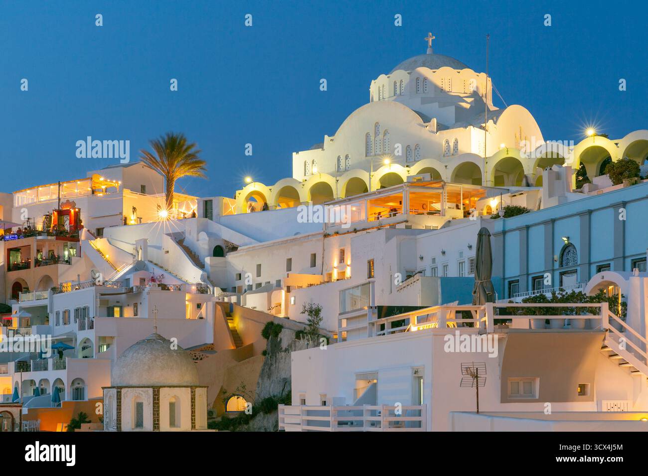 Illuminated Orthodox Metropolitan Cathedral and hillside buildings at ...