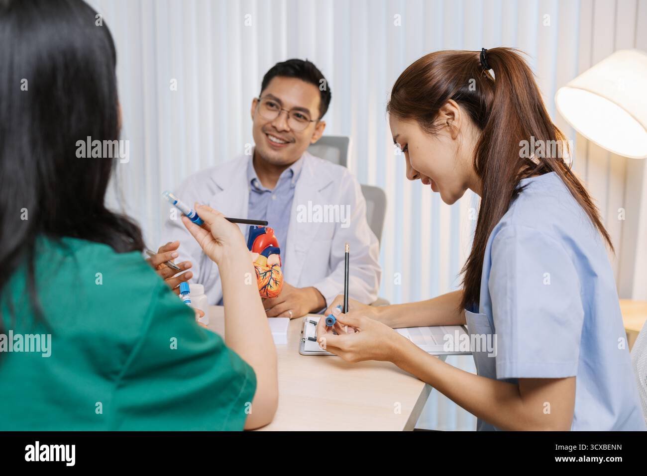 Group of doctors and nurses consulting about a complex patient case in ...