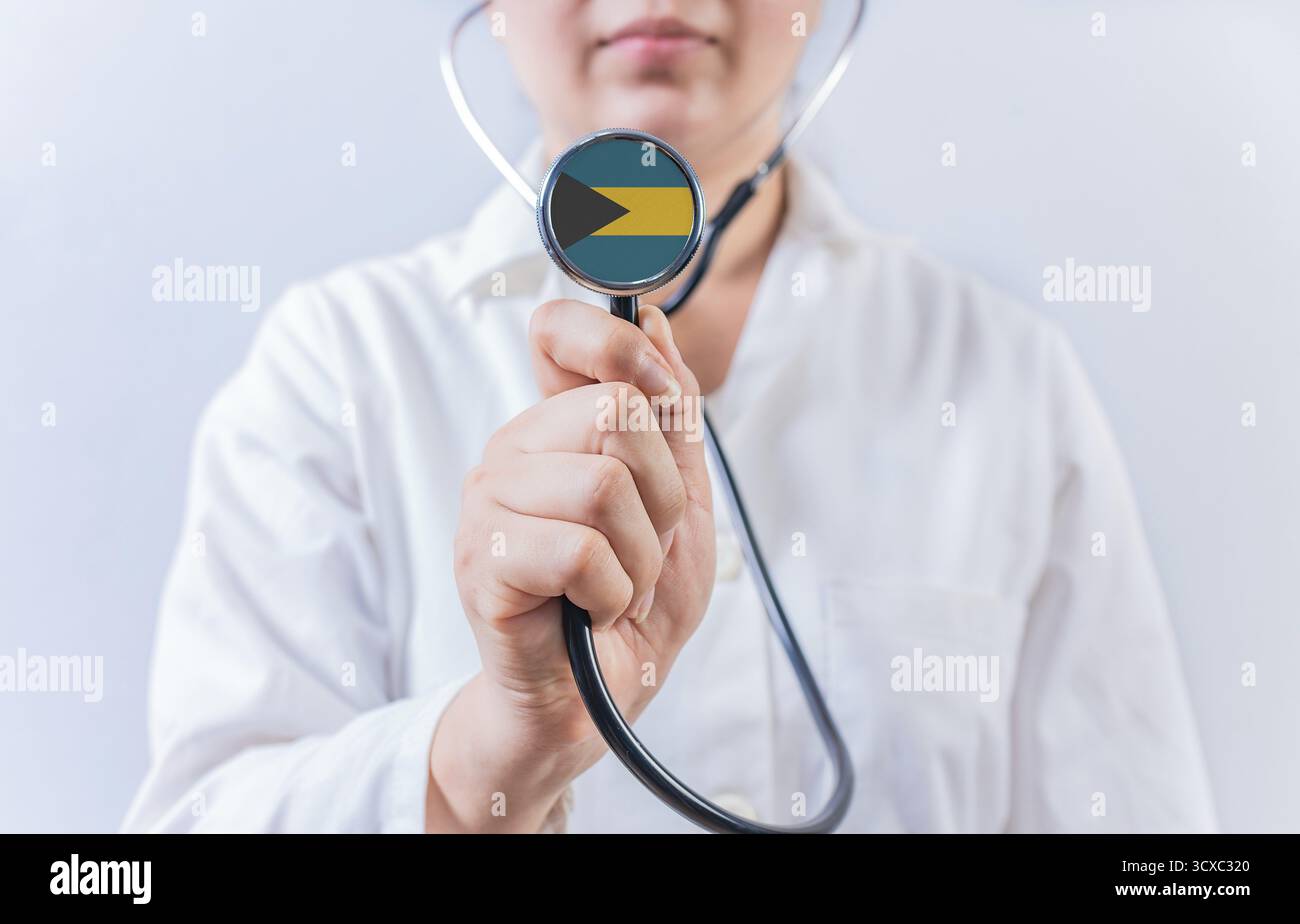 Female doctor holding stethoscope with Bahamas flag. National health ...