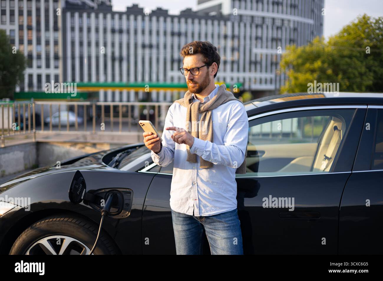 Electric car driver checking hi-res stock photography and images - Alamy
