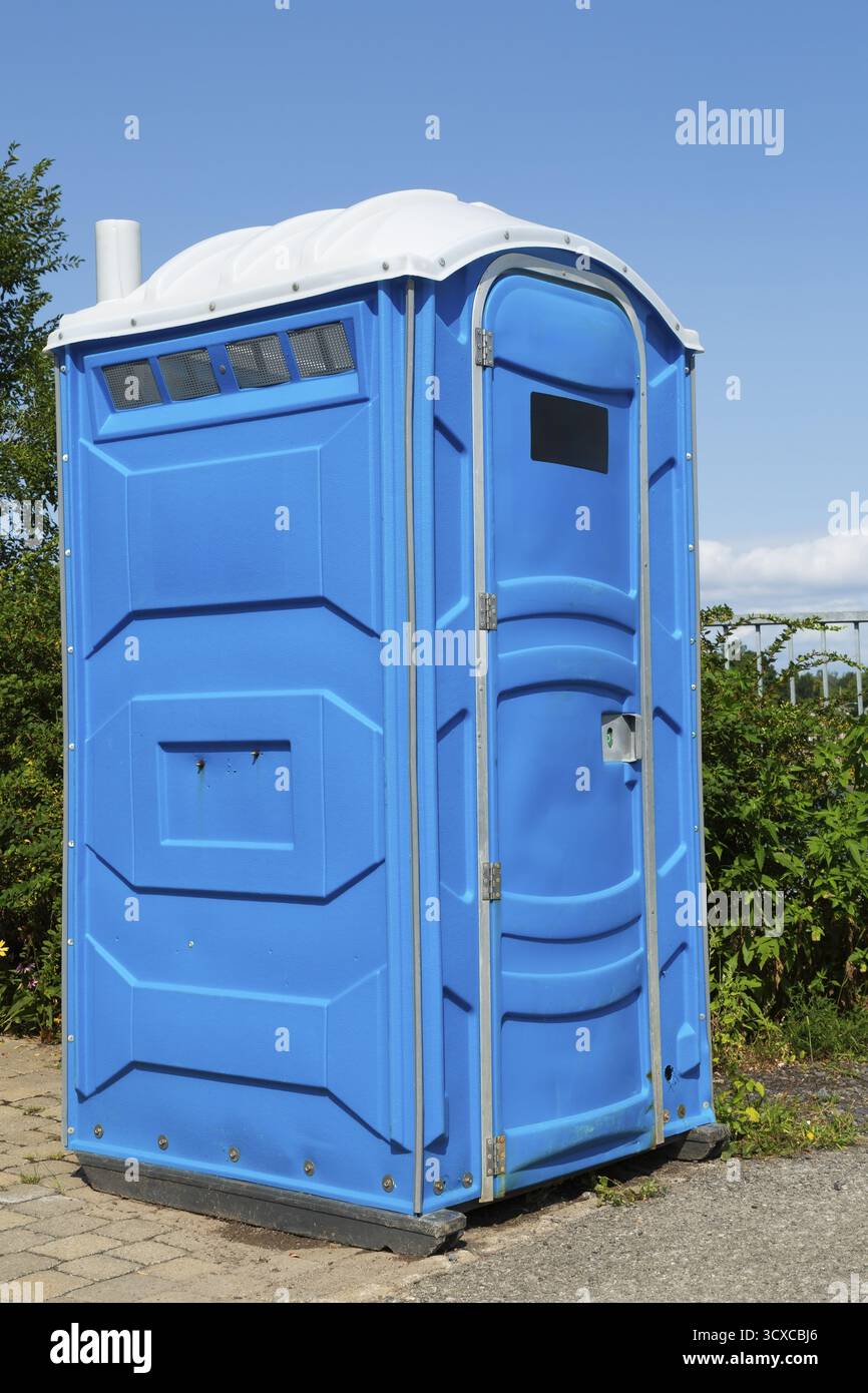 Blue and white portable chemical toilet temporarily installed by the ...