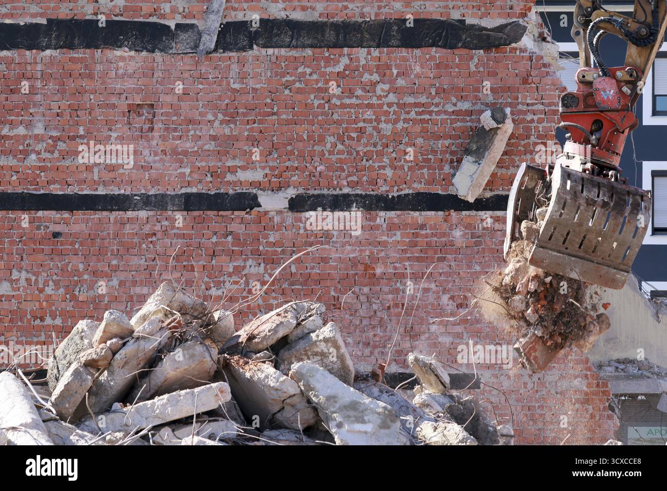 The arm of a giant excavator removes wall sections during the ...