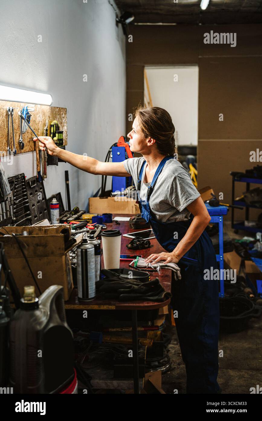 Woman organizing her workspace in auto repair shop Stock Photo - Alamy