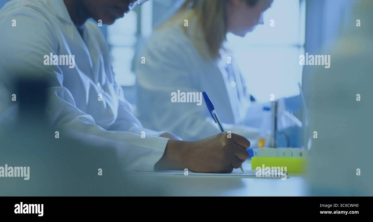 Documenting African American scientist writing with pen on clipboard at ...