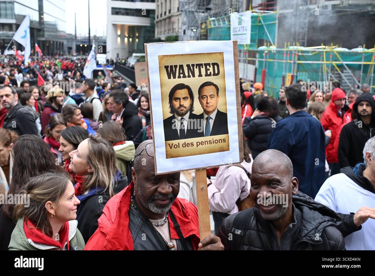 Two men hold a sign with a photo of Belgium's Prime Minister Bart De ...