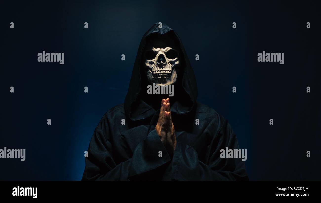 Praying Hands Wearing Hooded Robe in Blue Light Stock Photo - Alamy