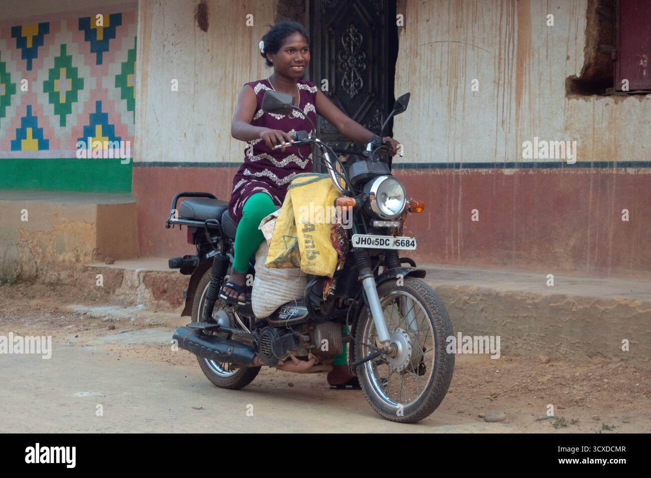 A rural tribal woman seen on a scooter during a community celebration ...