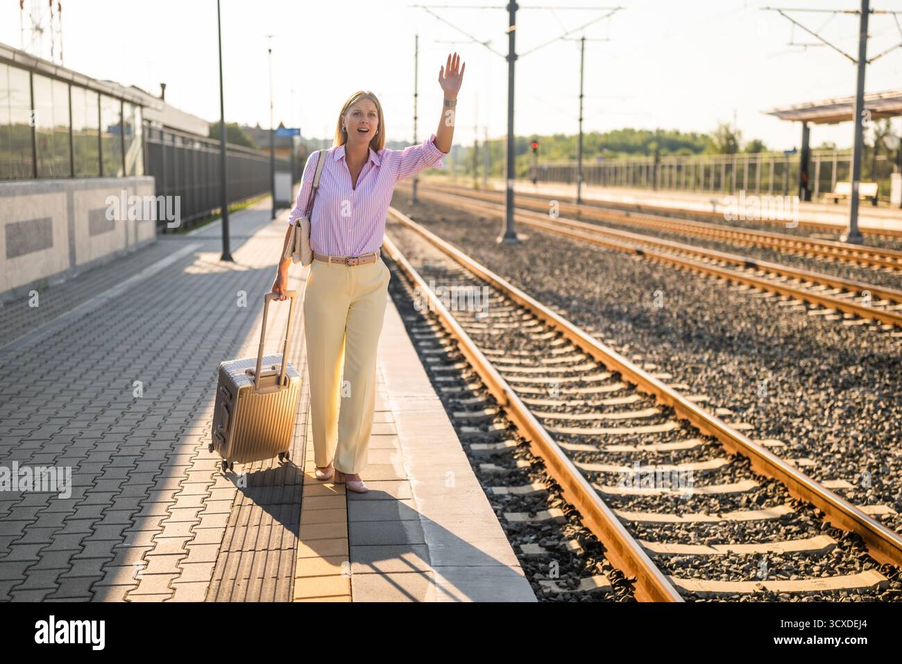 Frustrated businesswoman waving to a leaving train and running along ...