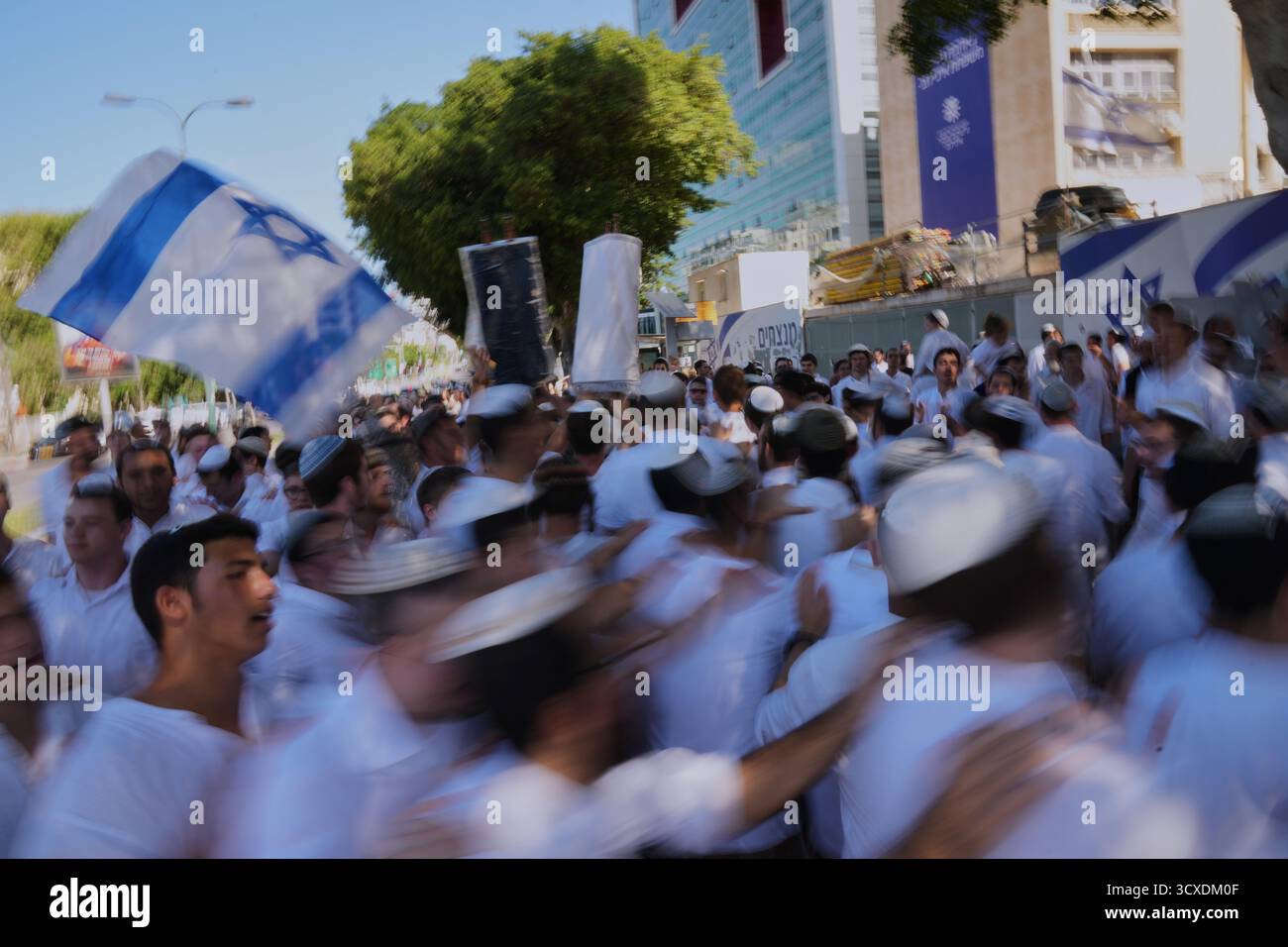 Jewish revelers dance in circle and hold up Torah scrolls as they ...