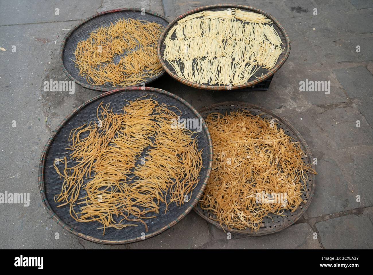 Fresh noodles drying on bamboo trays at a street market in Hoi An ...