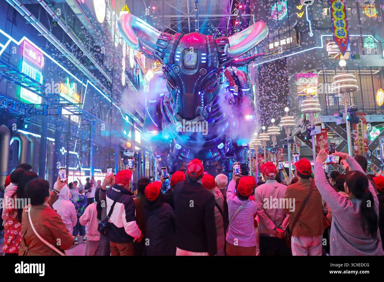 Tourists watch a ten-meter-tall mechanical ox Kui Niu moves in a ...
