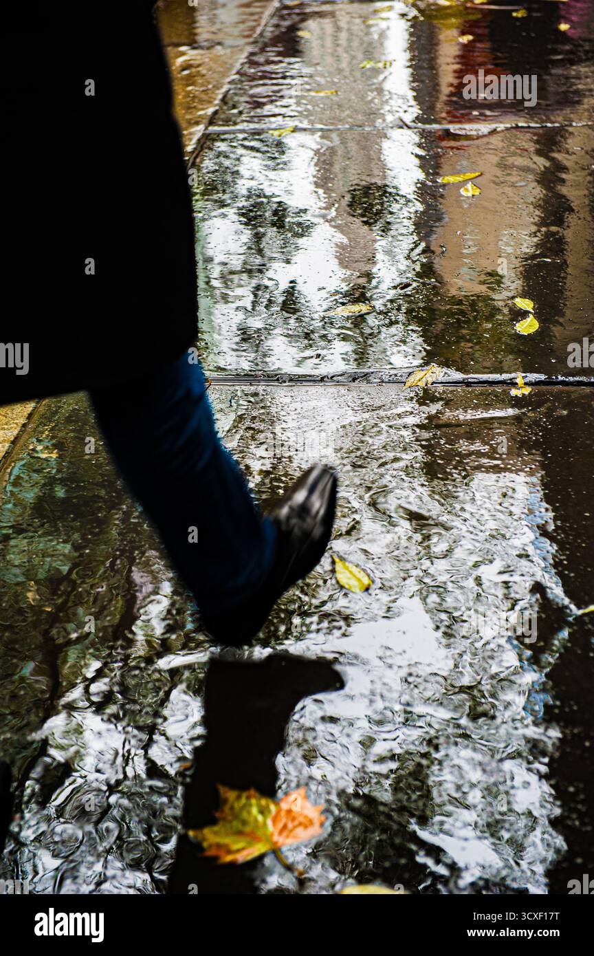 Man's foot stepping on a wet, rainy, sidewalk Stock Photo - Alamy