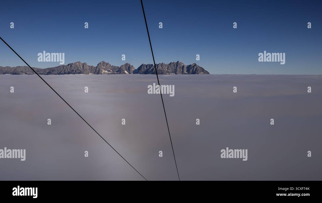 Aerial cable car descending through a sea of clouds with the Wilder ...