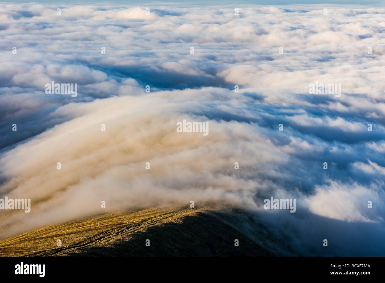 Dramatic temperature inversion with clouds flowing like a river over a ...
