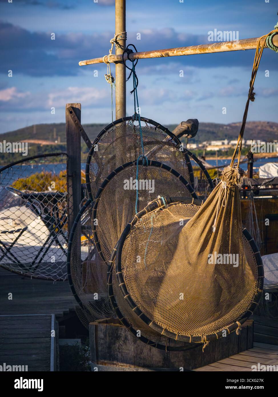 Traditional circular fishing nets drying on wooden pier in ...