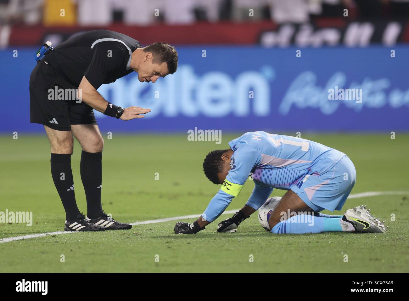 Referee talks to the goalkeeper Khalid Eisa of United Arab Emirates ...