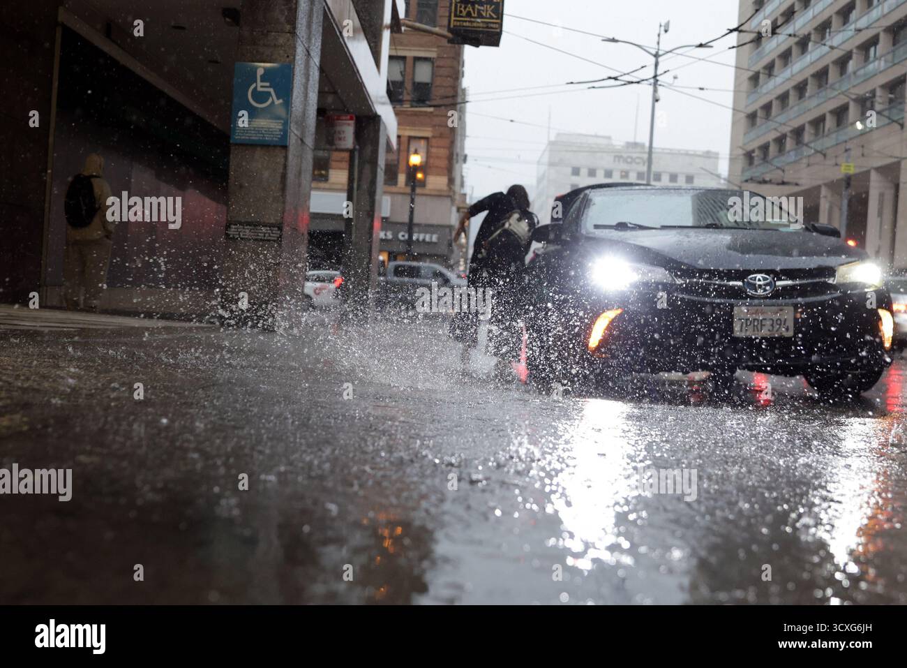 Rainwater sprays out of a drain on Stockton Street in San Francisco on ...