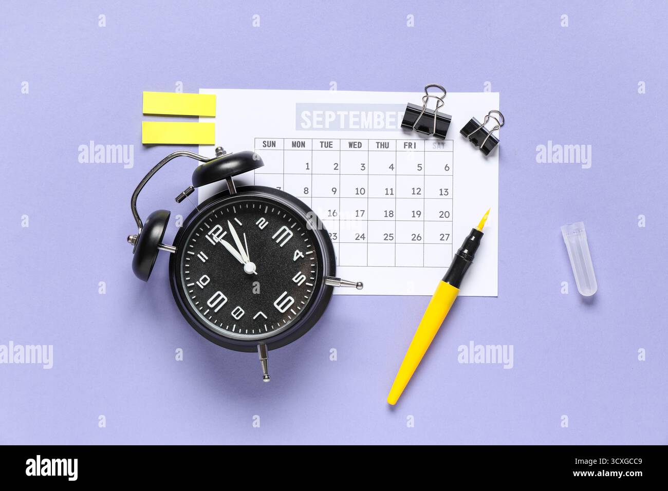 Calendar with alarm clock, felt tip pen, stickers and binder clips on ...